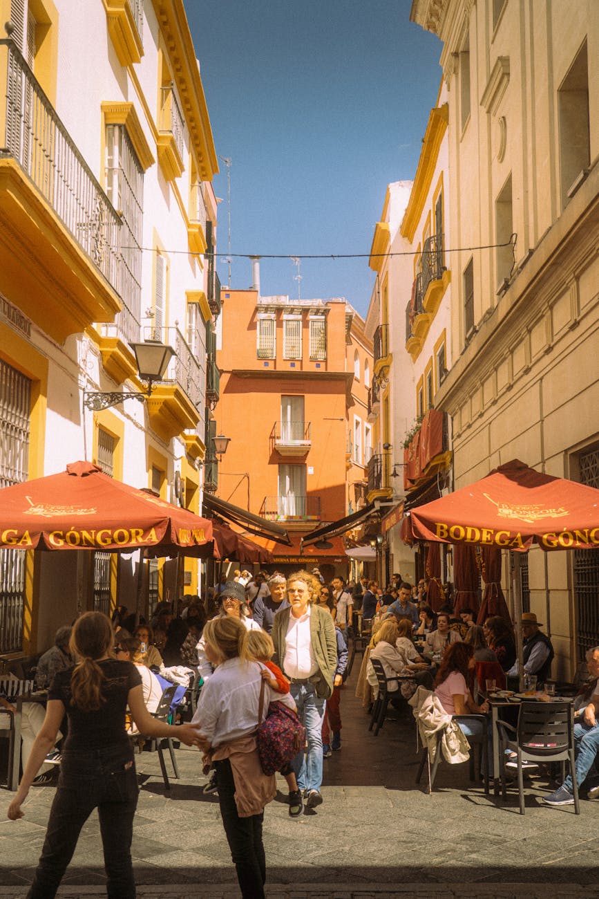 People enjoying outdoor cafes on a sunny street in Seville