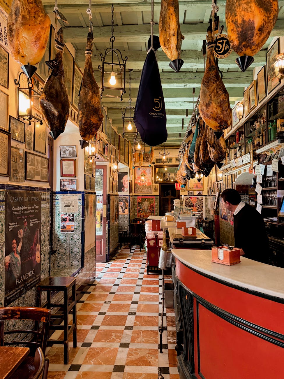 Traditional tapas bar in Seville with cured hams hanging from the ceiling