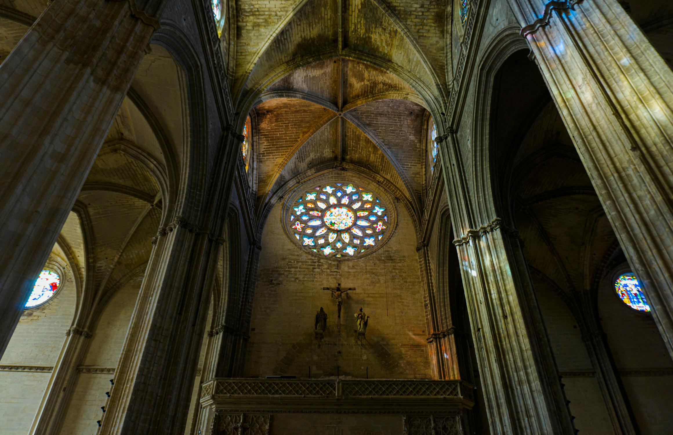 Interior of Seville Cathedral showing gothic arches and stained glass windows