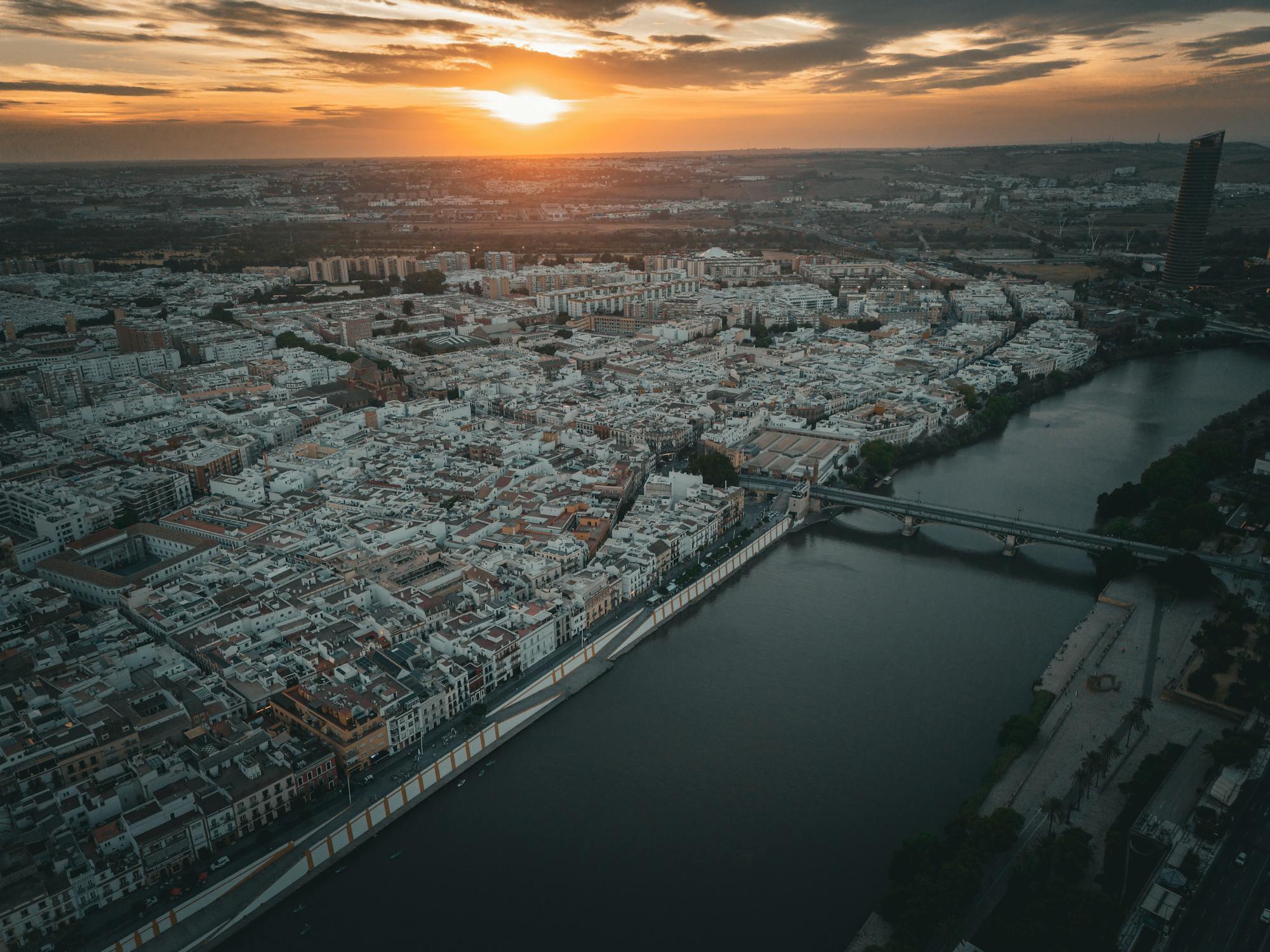 Aerial view of Seville showing the Guadalquivir River and cathedral at golden hour