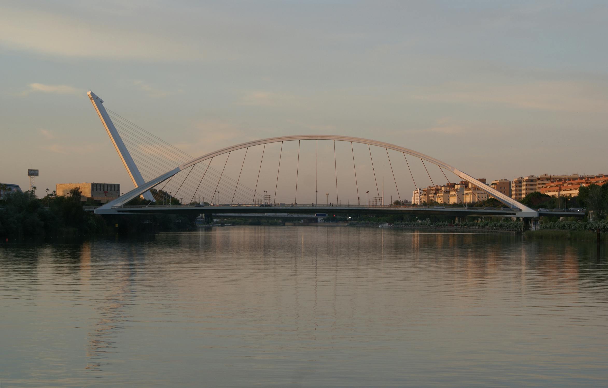 La Barqueta Bridge illuminated at evening over the Guadalquivir River in Seville