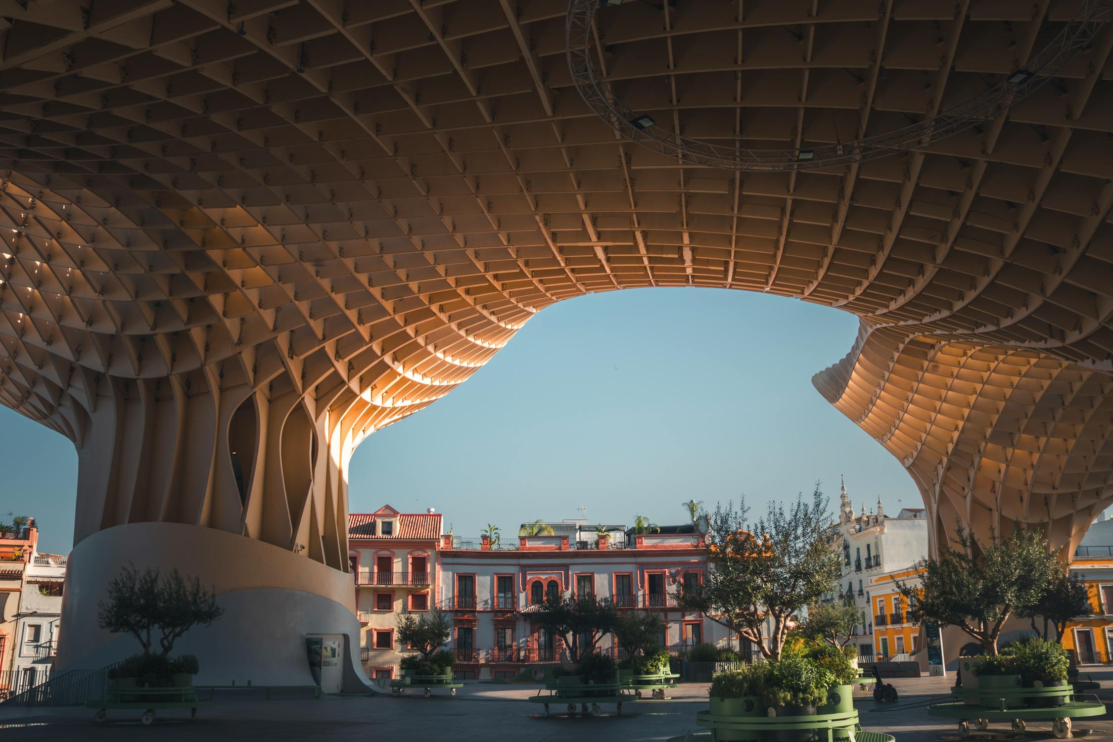 The Metropol Parasol wooden structure in Seville with blue skies and historic buildings below