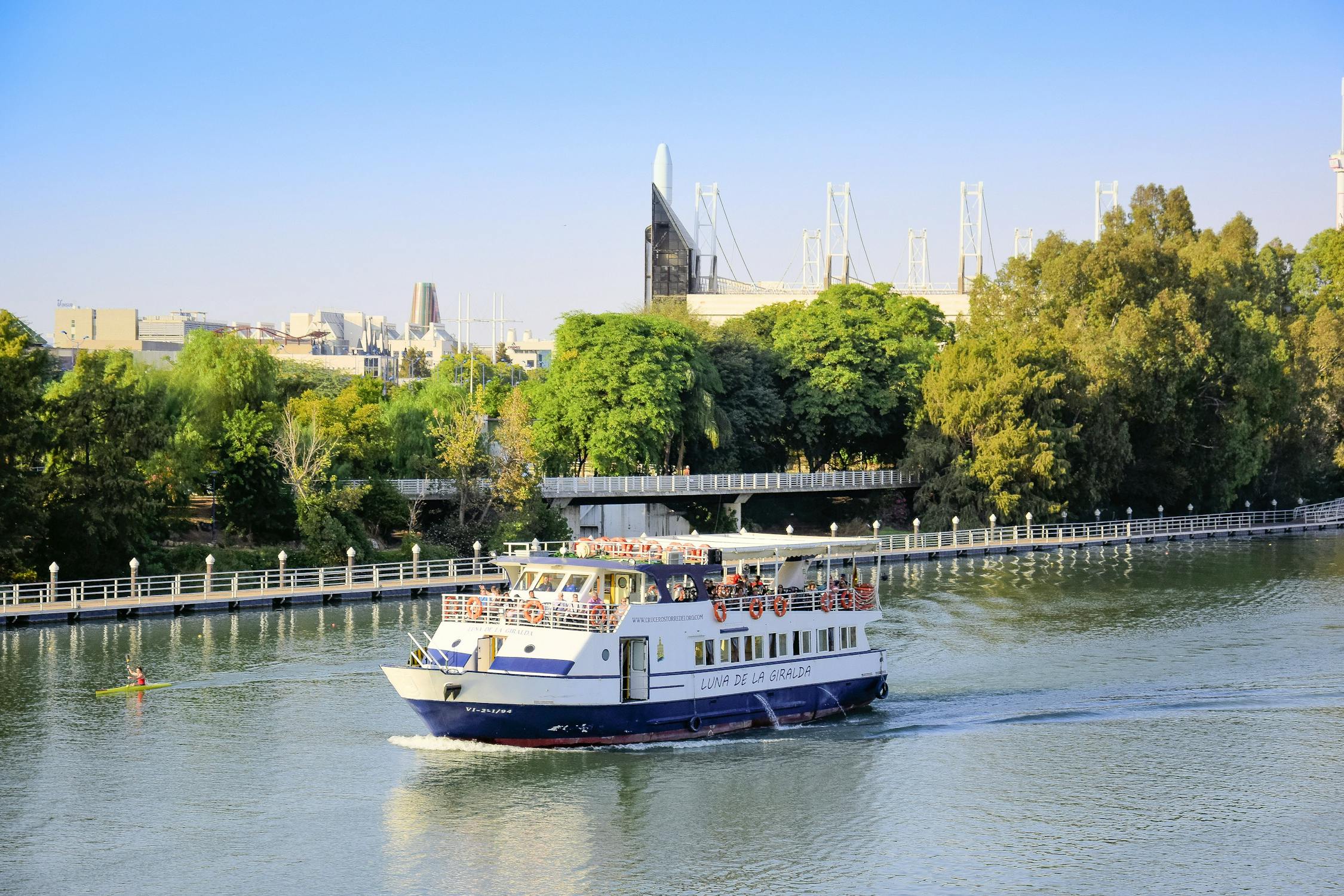 A sightseeing cruise boat sailing on the Guadalquivir River in Seville