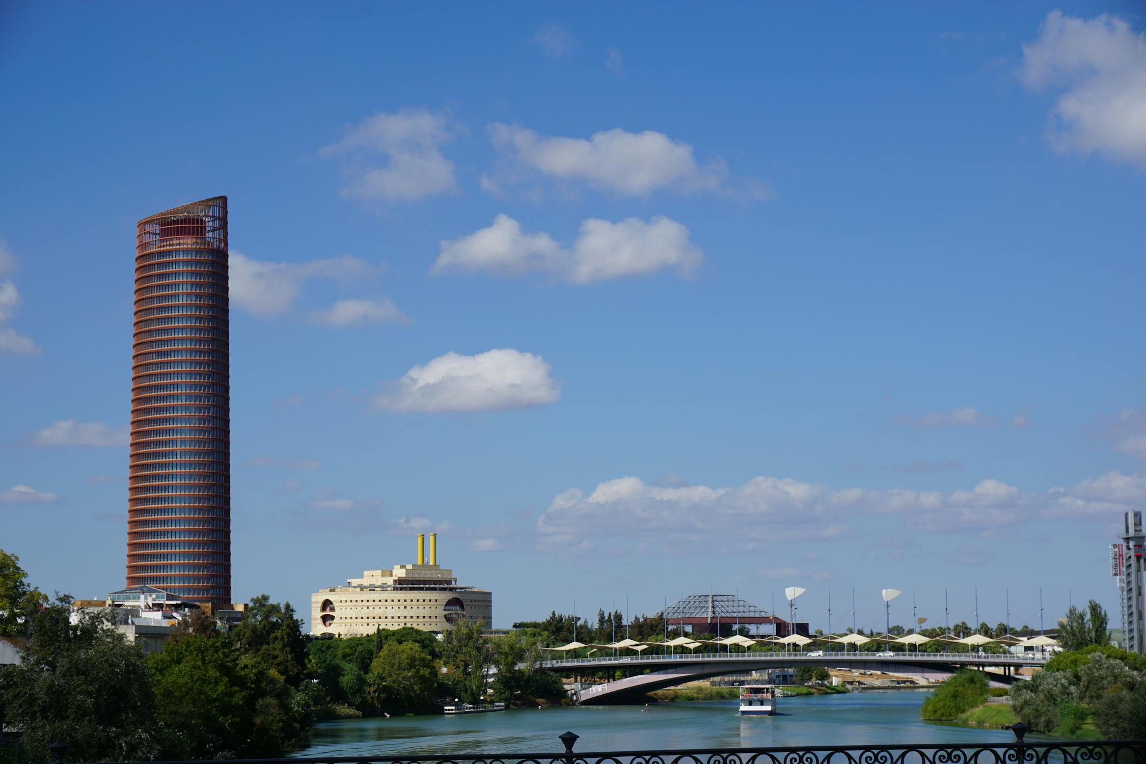 Torre Sevilla skyscraper and Guadalquivir River under blue sky in Seville
