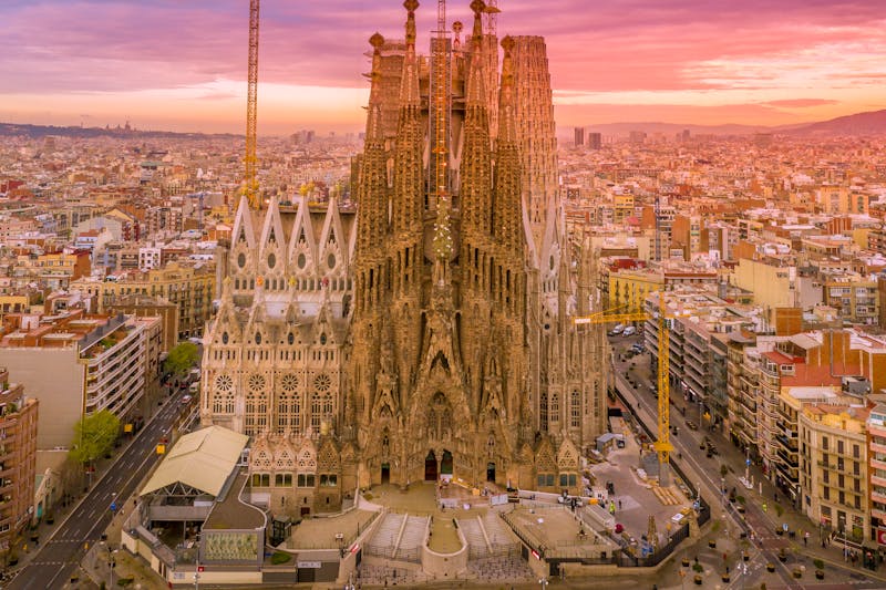 Breathtaking aerial view of Sagrada Familia during sunset with the city stretching to the Mediterranean