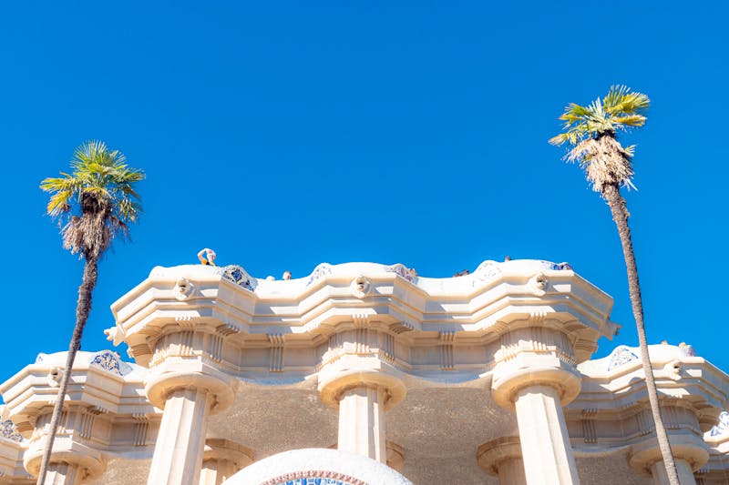 Colorful mosaic architecture and palm trees at Park Guell in Barcelona