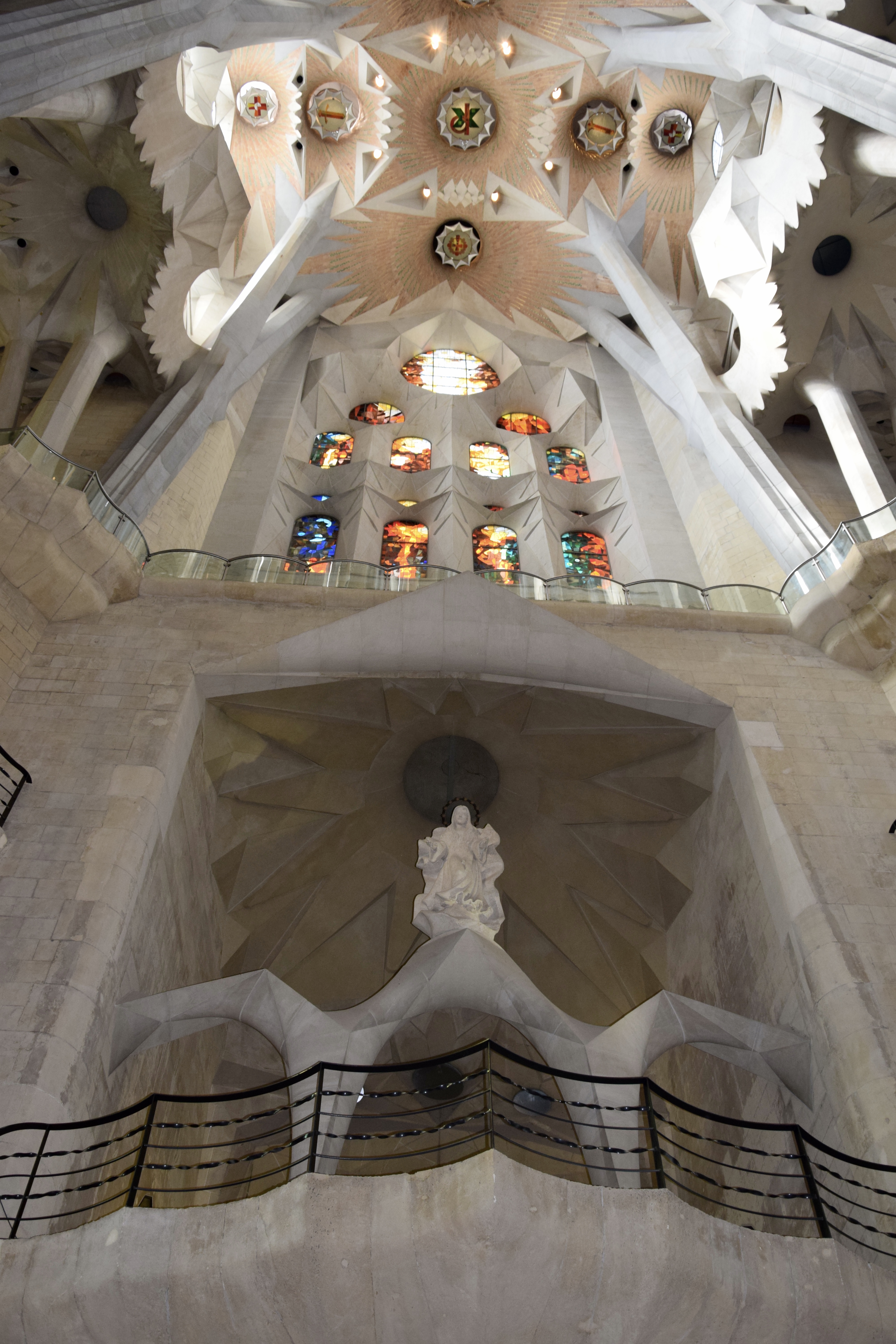 Colorful stained glass windows casting rainbow light inside the Sagrada Familia basilica