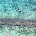 Person snorkeling in crystal clear water