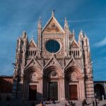 The Gothic facade of Siena Cathedral with its distinctive black and white marble stripes