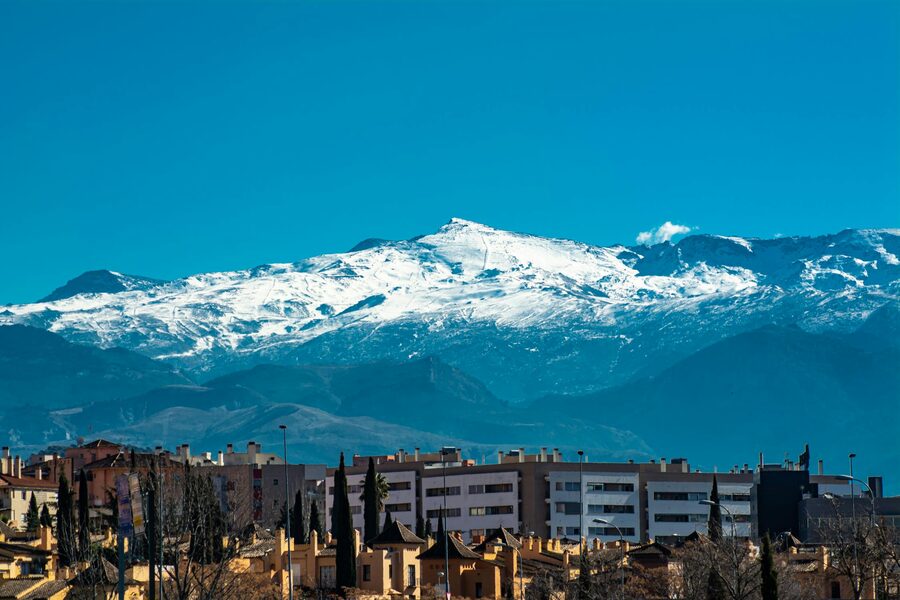 Panoramic view of snowy Sierra Nevada mountains towering over Granada city
