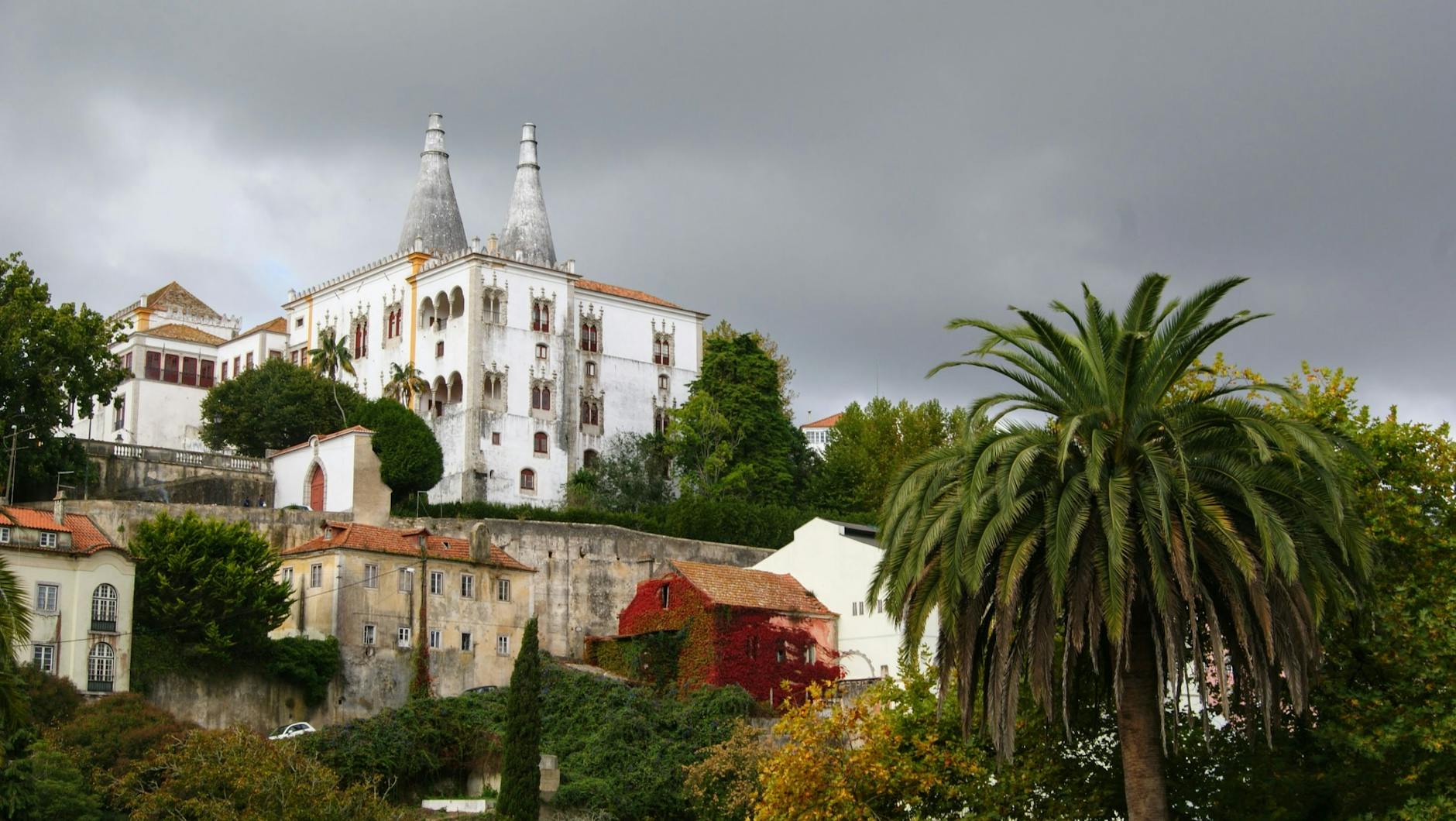 Sintra National Palace with its iconic white chimneys surrounded by greenery