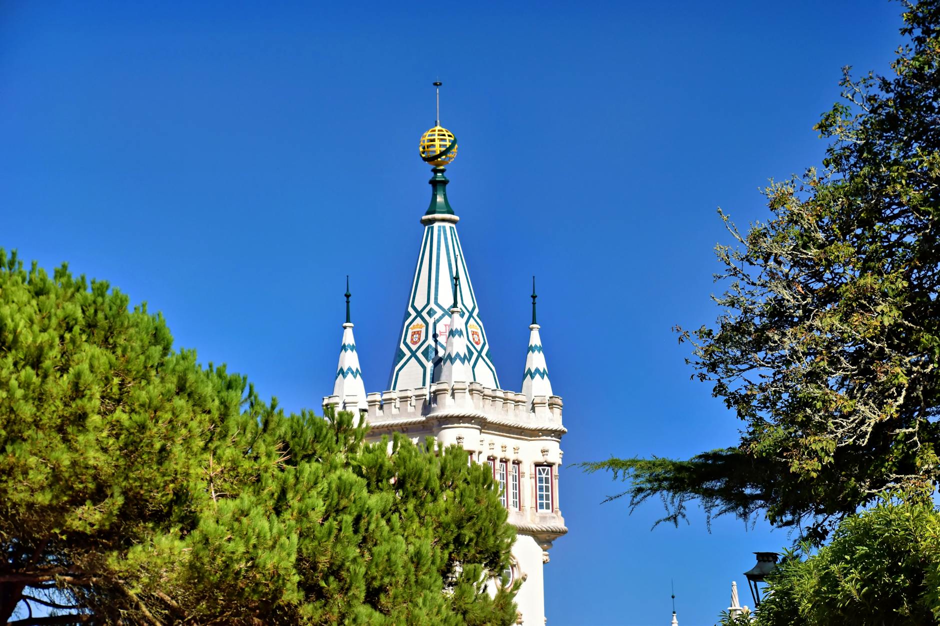 Sintra tower rising above lush green hillside against clear blue sky