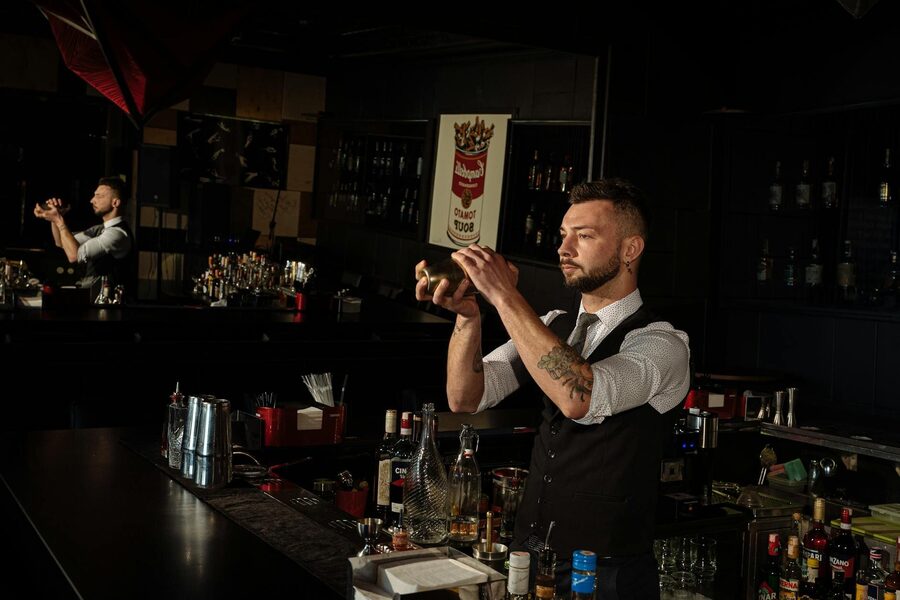 Skilled bartender shaking a cocktail mixer