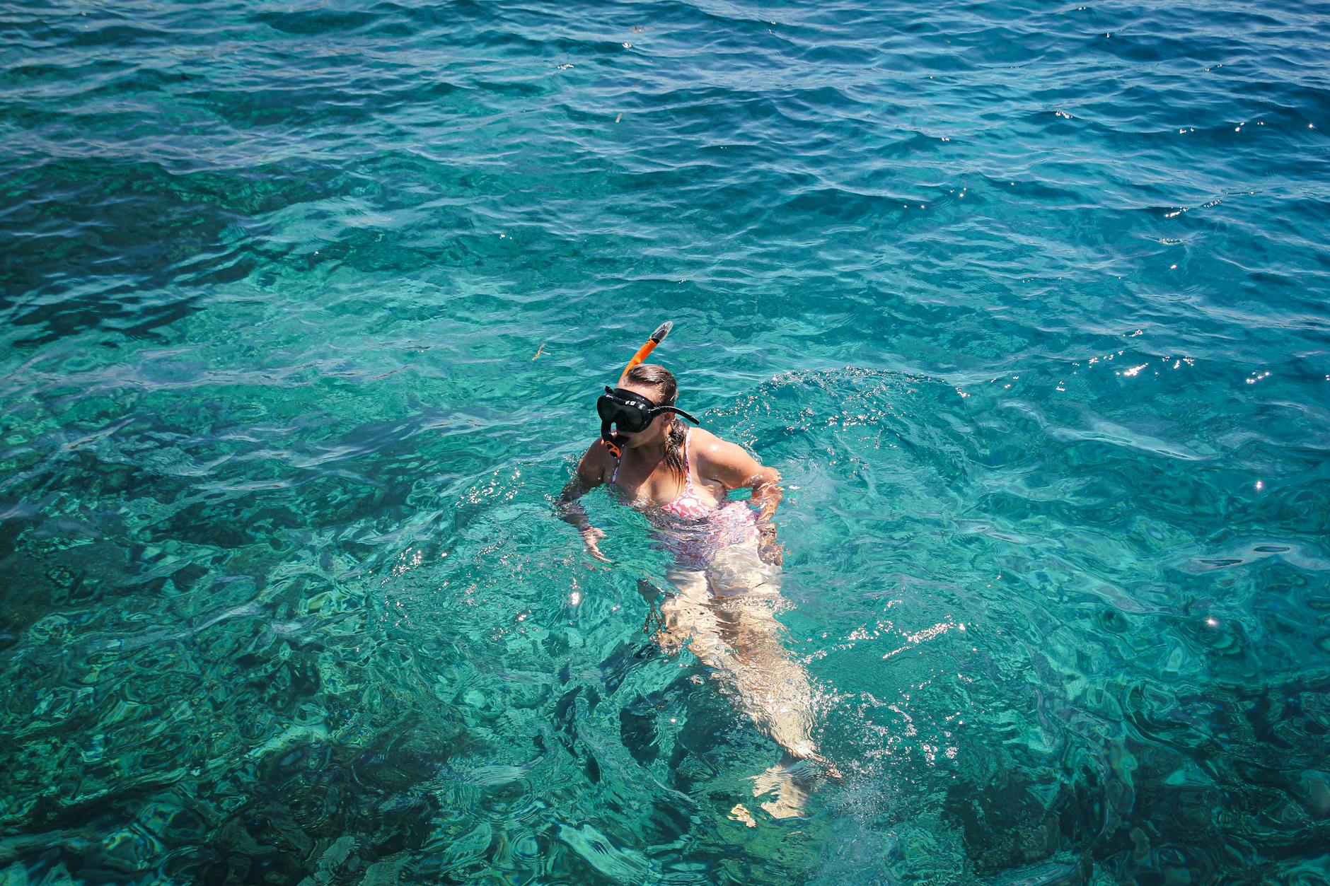 Person snorkeling in crystal clear turquoise Mediterranean water