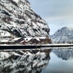 Snowy fjord village of Flam Norway with mountain reflections in winter
