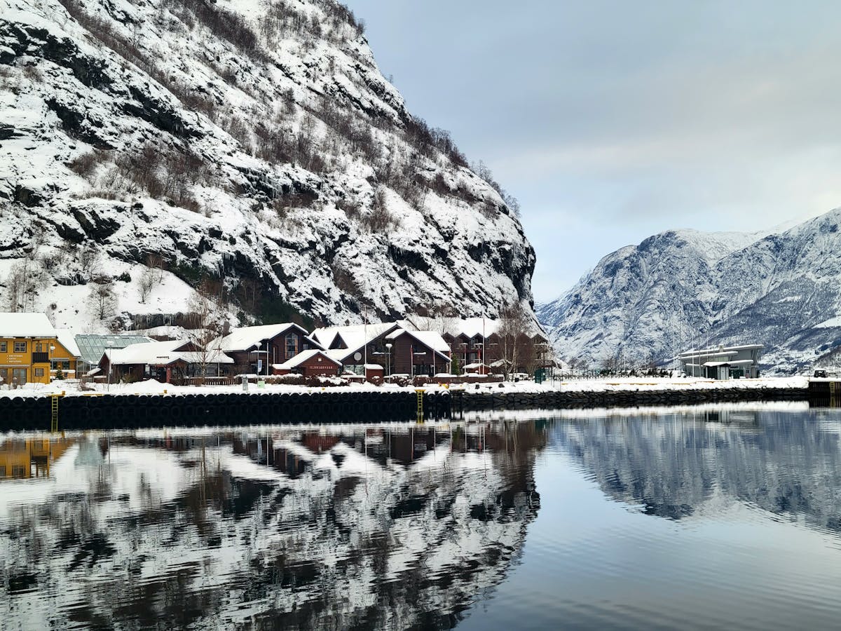 Snowy fjord village of Flam Norway with mountain reflections in winter