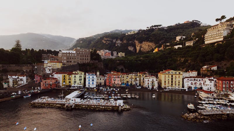 Picturesque coastal view of Sorrento with colorful buildings and motorboats moored in the marina