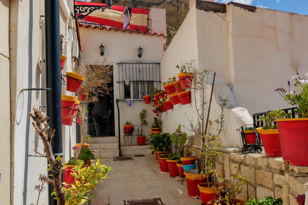 A Spanish alleyway decorated with colorful ceramic flower pots