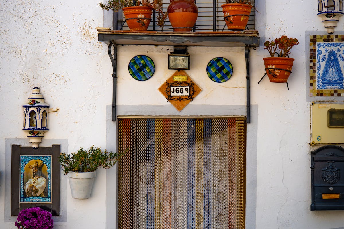 Colorful ceramic pots surrounding an ornate door in a Spanish courtyard