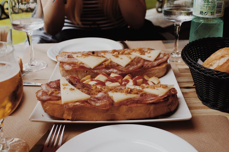 Spanish toast topped with ham and garnish served at outdoor restaurant