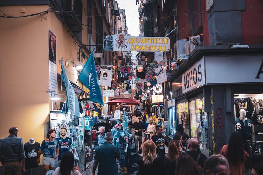 Crowded narrow street in the Quartieri Spagnoli neighborhood of Naples with colorful market stalls