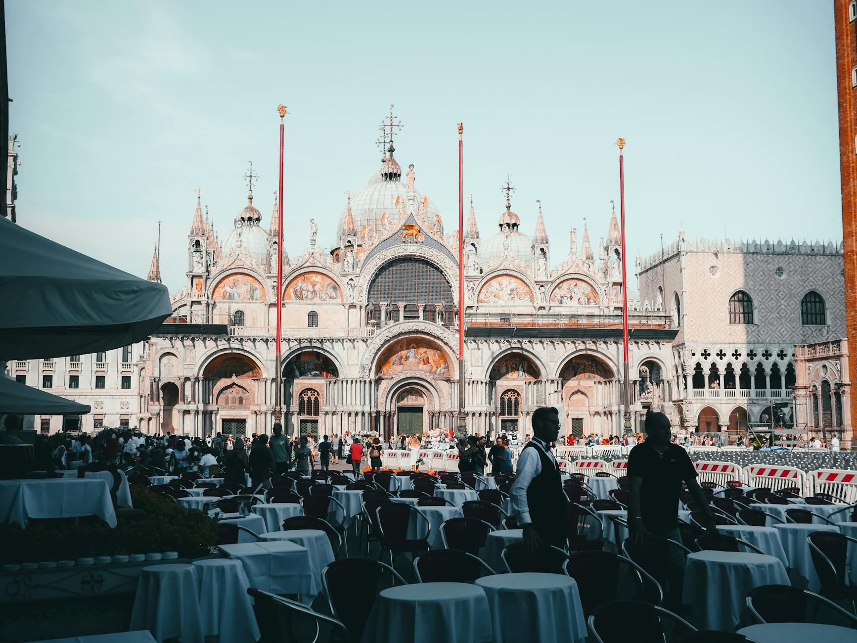 St Marks Basilica in Venice with outdoor seating and travelers