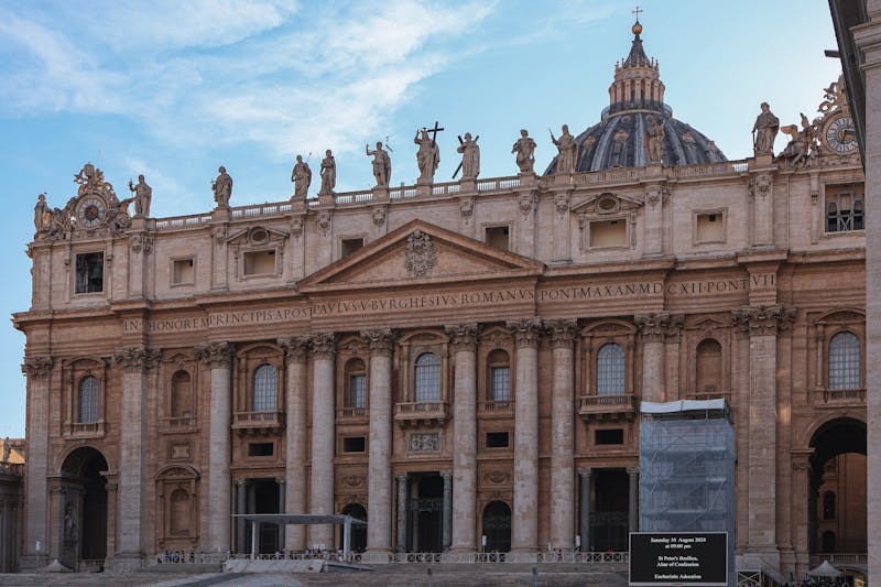 The front facade of St. Peter's Basilica showing the grand columns and statues along the roofline