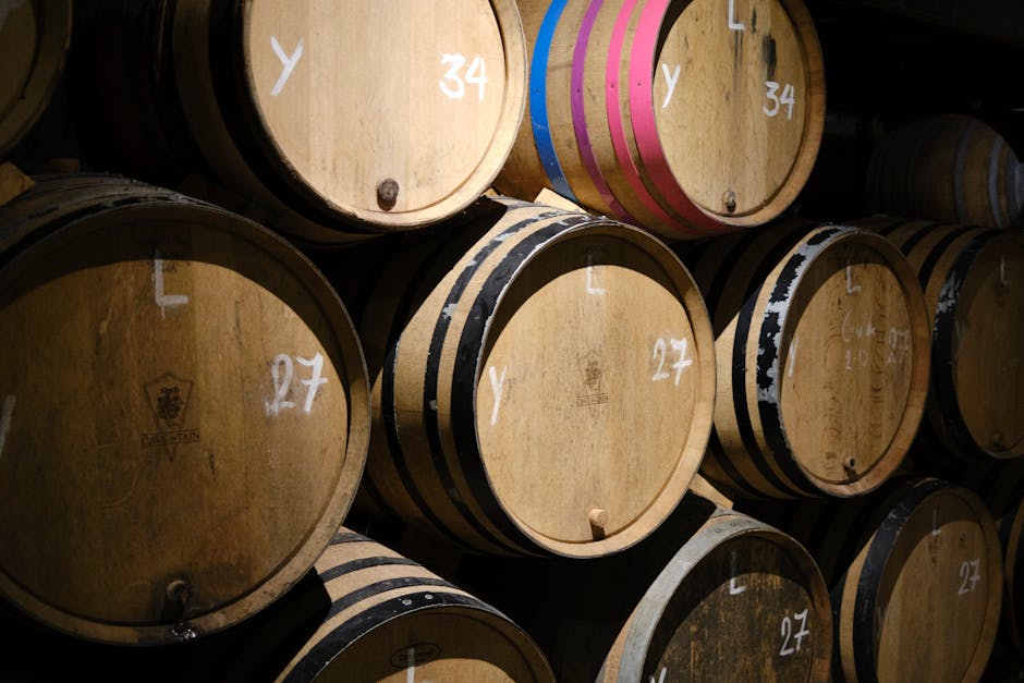 Stacked wooden wine barrels aging in a winery cellar