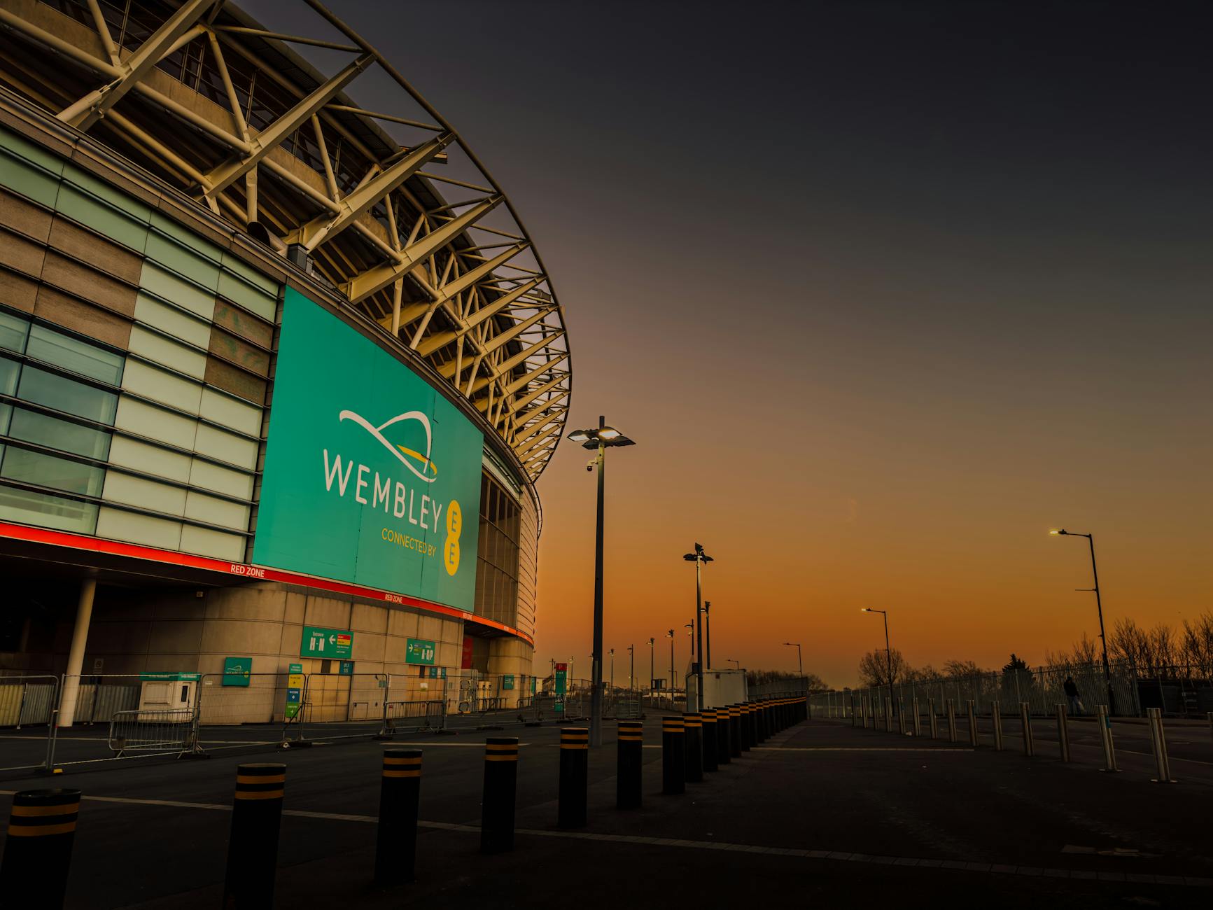 Wembley Stadium at twilight with dramatic sky