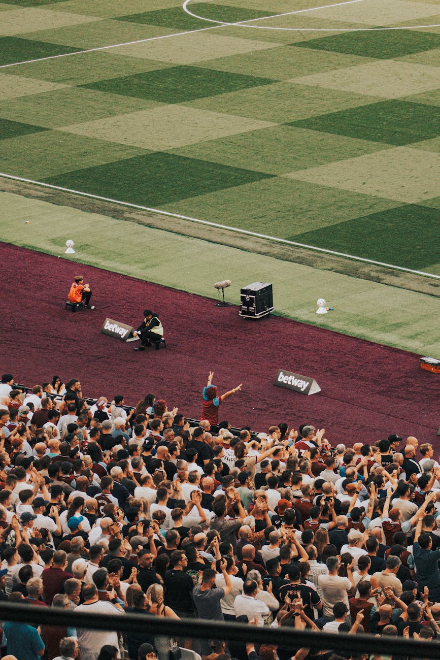 Football fans cheering at London Stadium during match