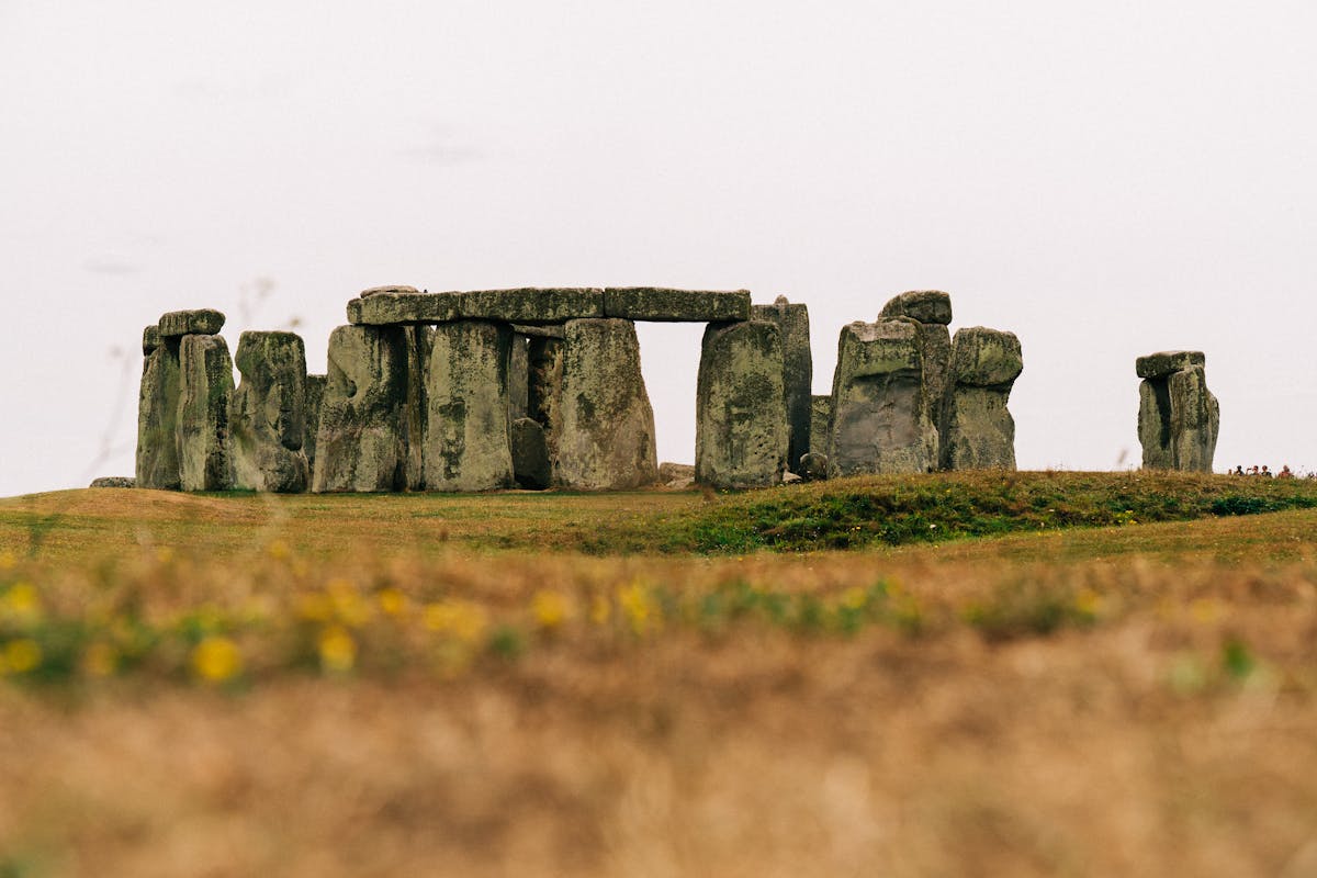 Stonehenge stones standing in a grassy field on an overcast day