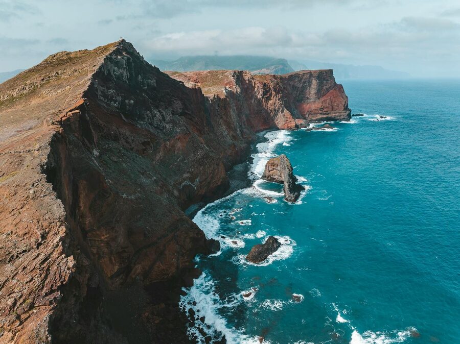 Aerial view of Madeira island rugged cliffs meeting the Atlantic Ocean