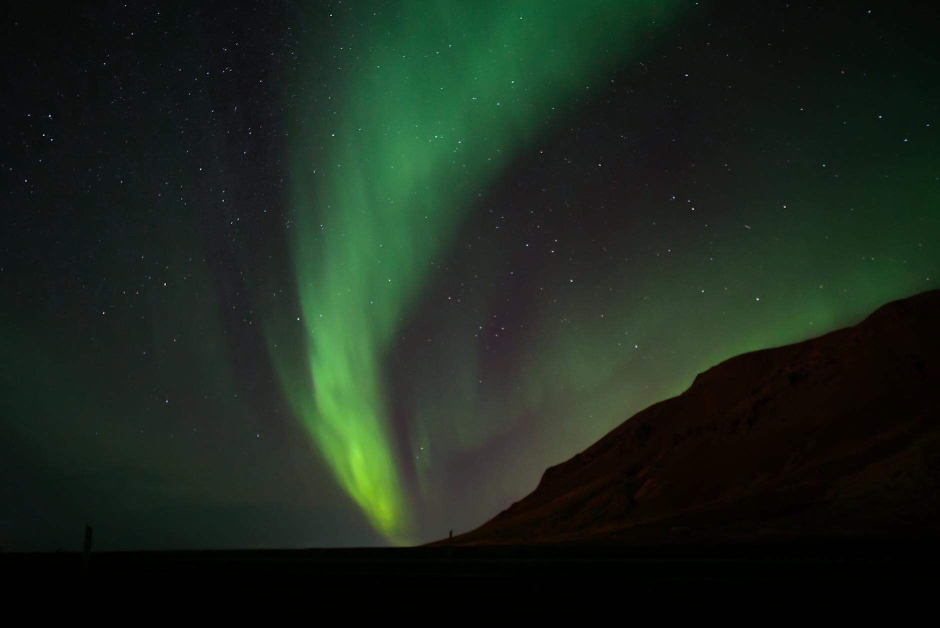 Stunning aurora borealis illuminates the night sky over Selfoss, Iceland, with starry backdrop.