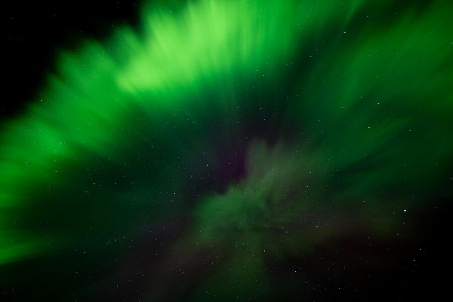 Stunning green aurora borealis illuminating the starry night sky over Iceland.