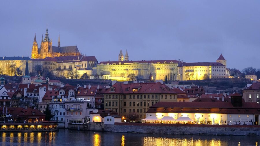 Prague Castle and surrounding historic buildings illuminated at twilight