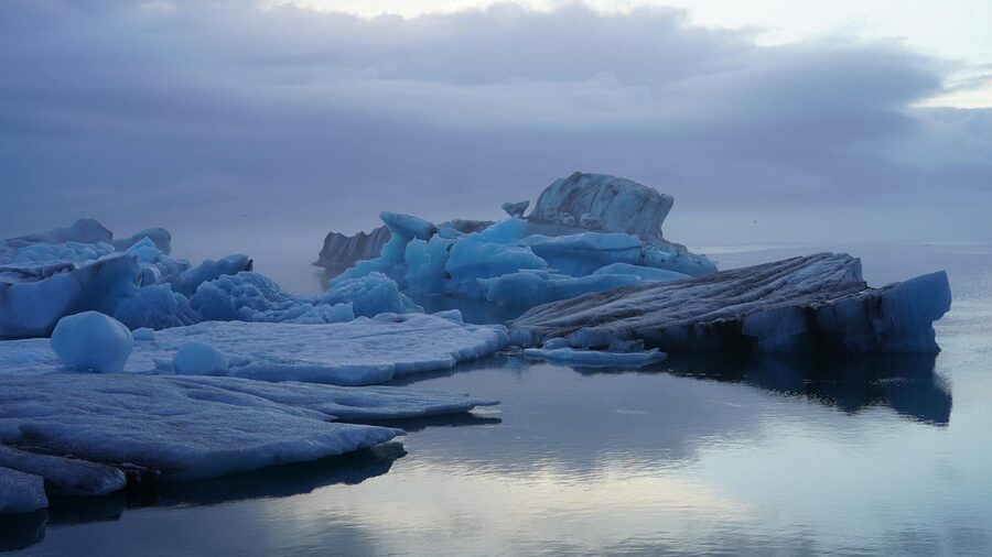 Stunning view of floating icebergs in Iceland's serene waters under a twilight sky.