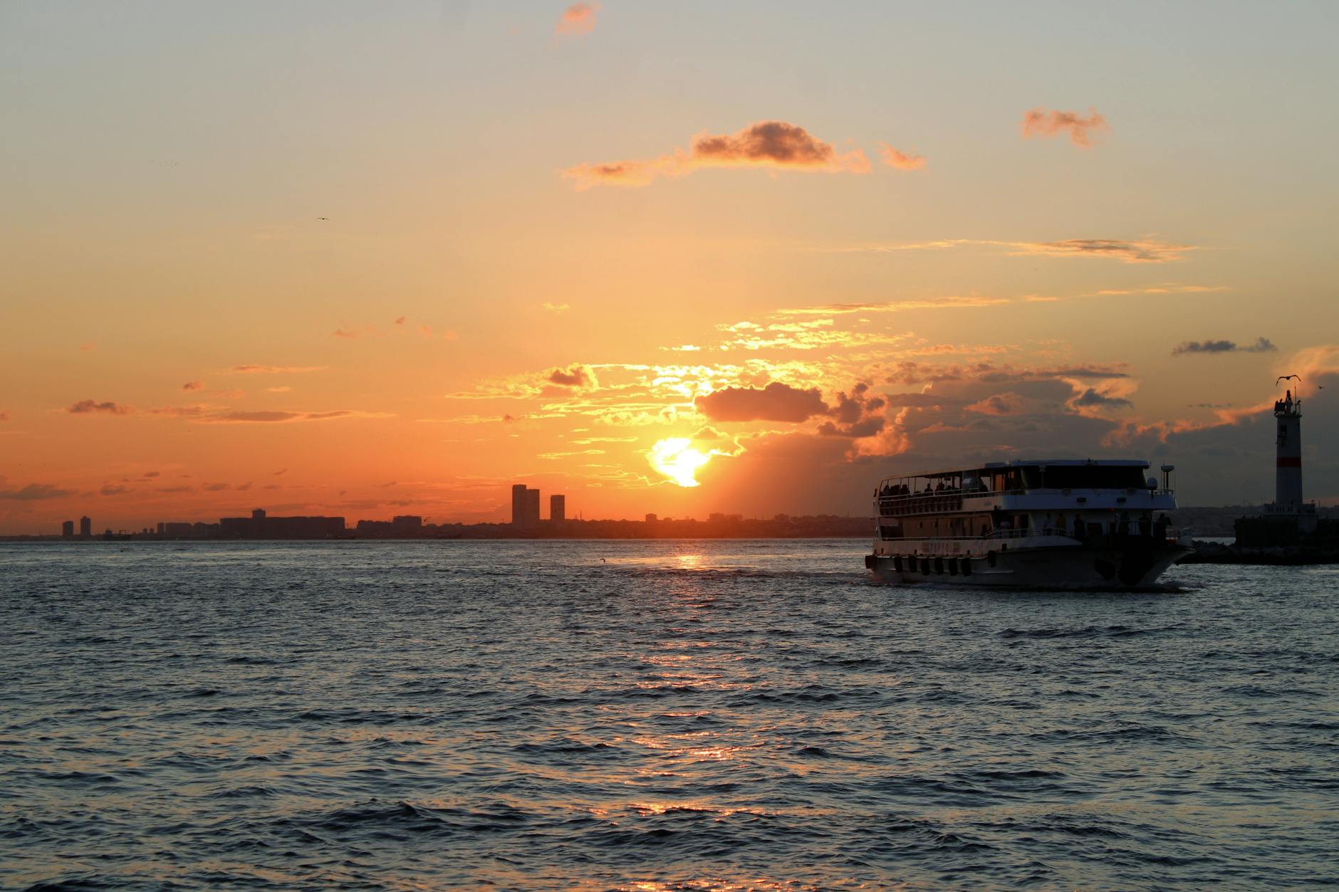 Silhouette of a boat during a sunset cruise on calm ocean waters