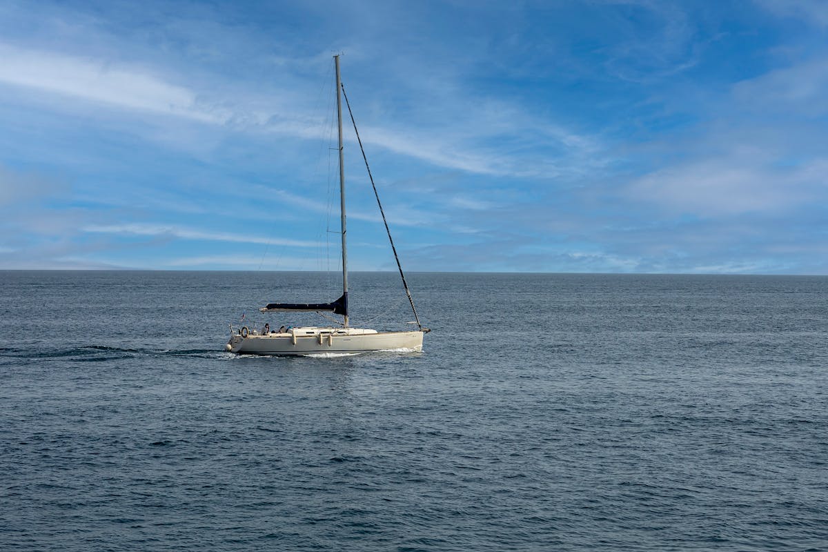 Sailboat navigating across Mediterranean Sea near Santa Pola under clear blue sky