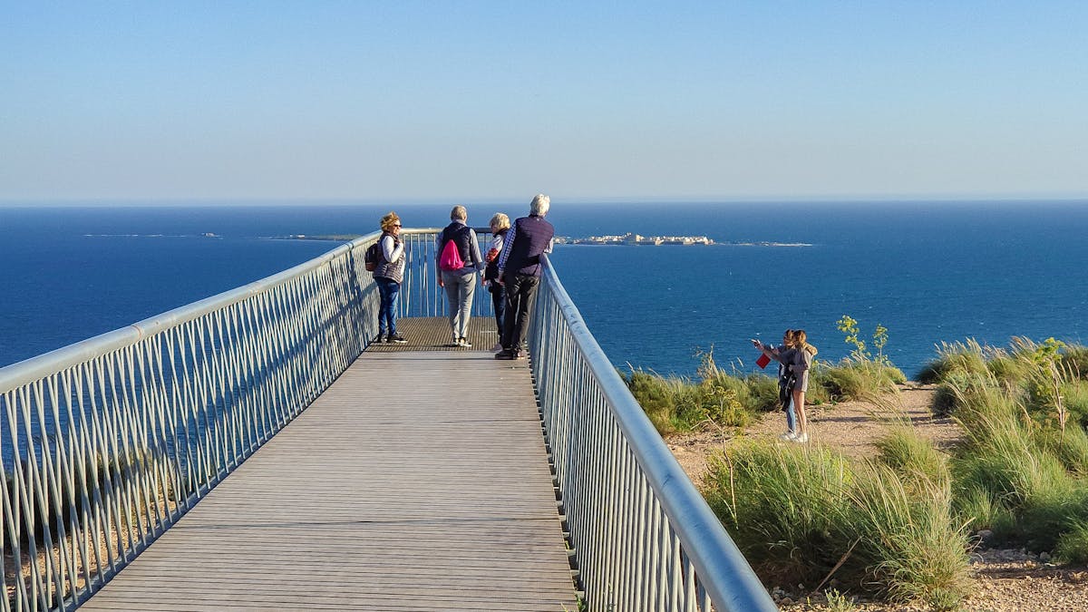 People enjoying ocean views from walkway at Santa Pola cliff Spain