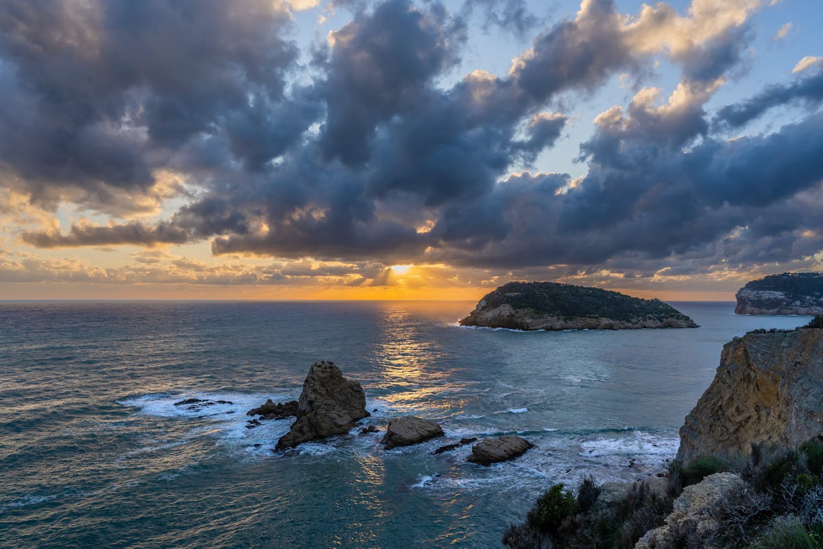 Sunset over rocky coastline and island near Alicante Spain