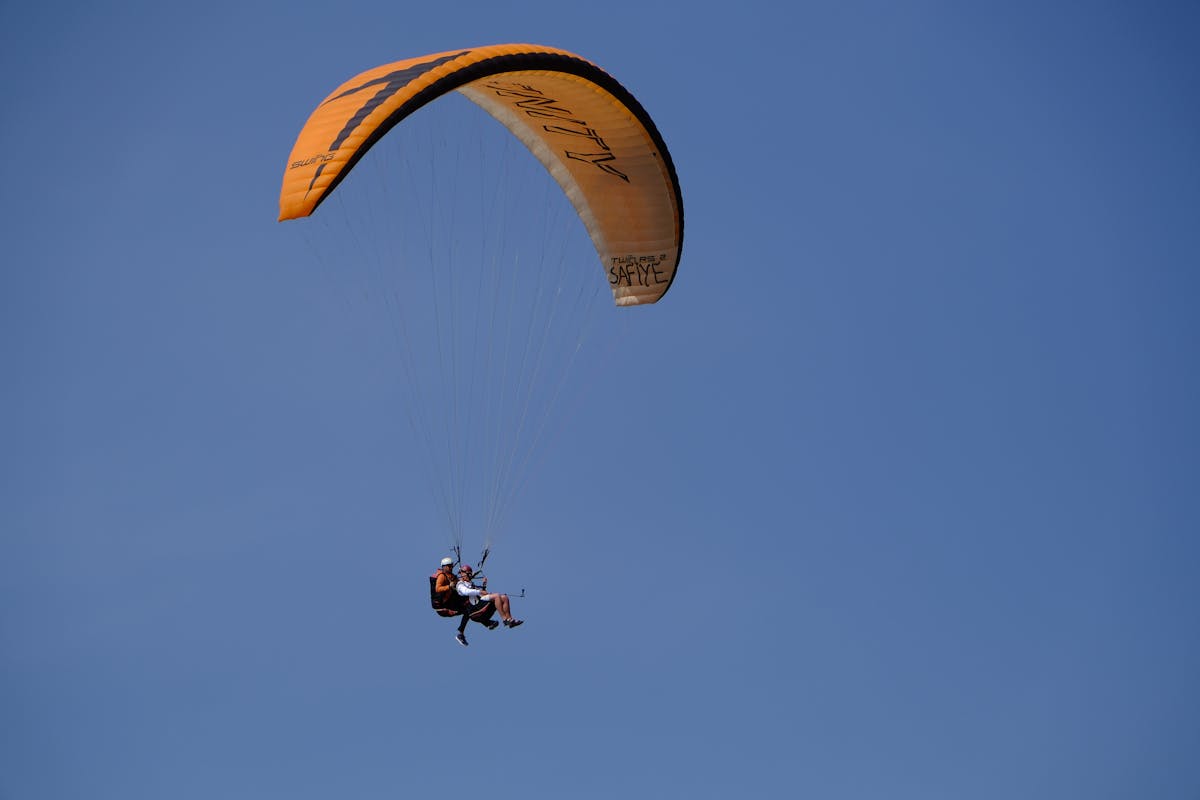 Tandem paragliding flight with clear blue skies