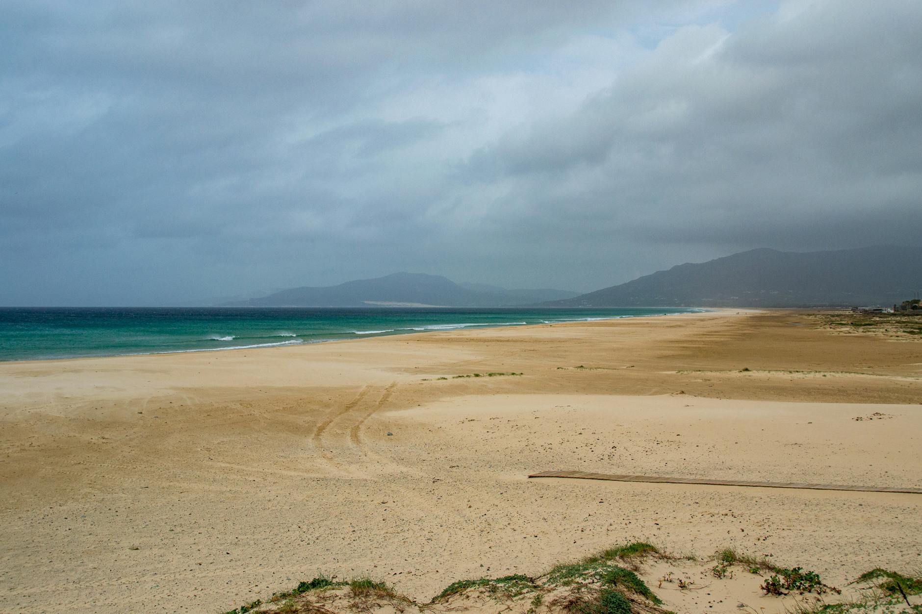 Calm and expansive sandy beach in Tarifa Spain with cloudy sky