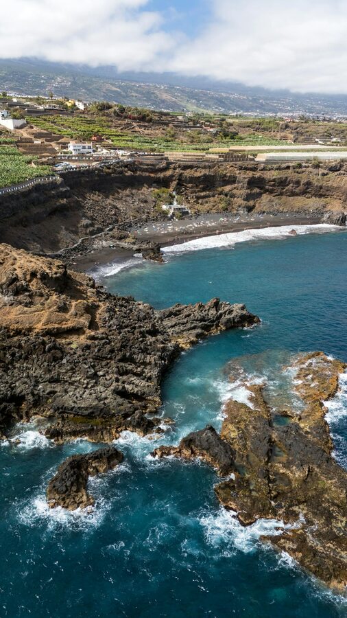 Rocky coastal cliffs overlooking crystal clear turquoise water in southern Tenerife
