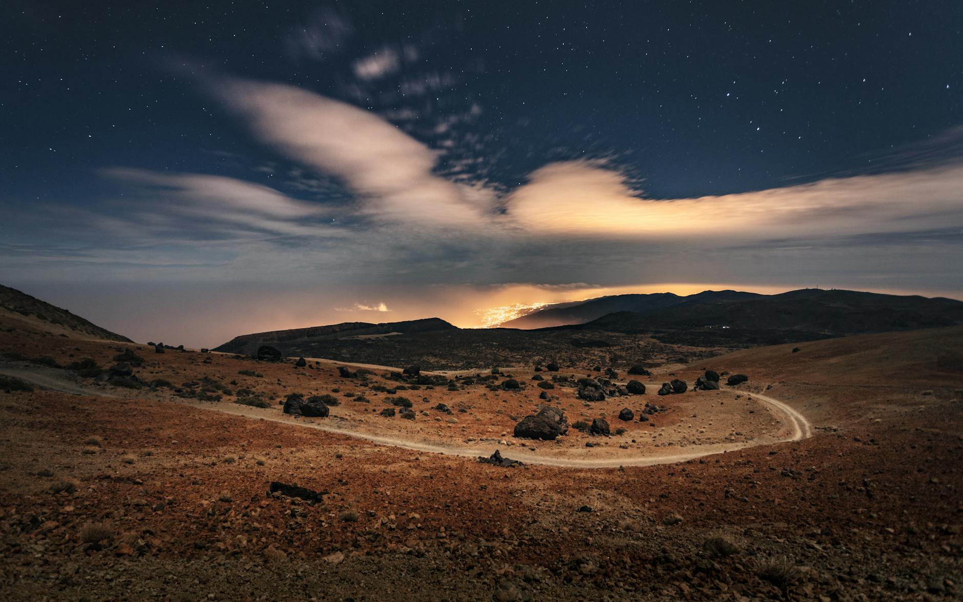 Stars photographed over a dark landscape in Tenerife at night