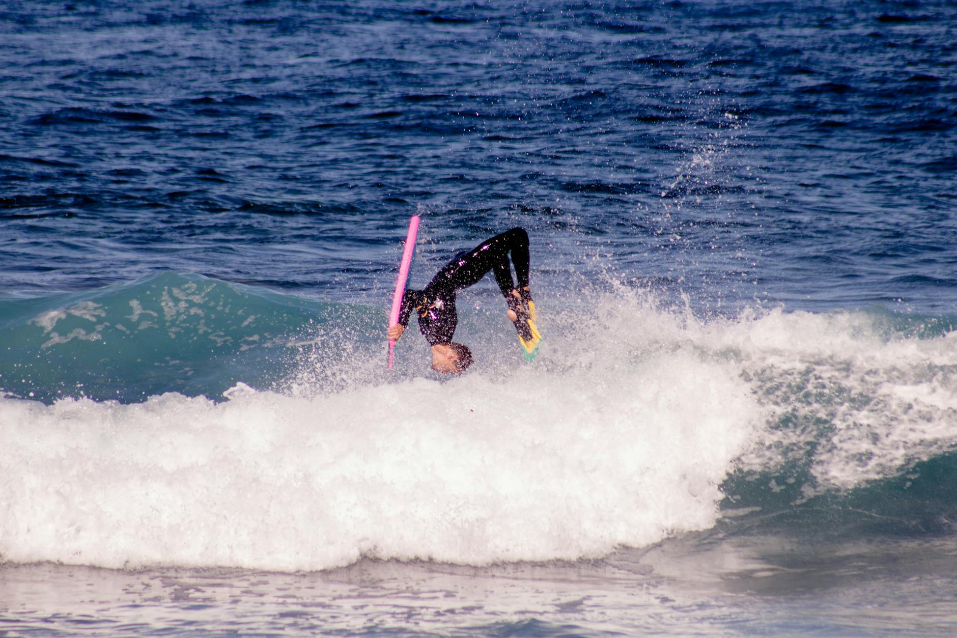 A surfer rides a wave at a beach in Tenerife Spain