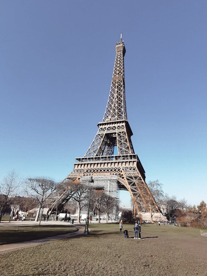 Tourists enjoying the Eiffel Tower on a sunny day in Paris