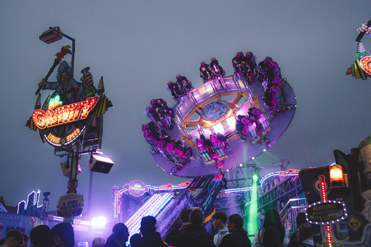 People enjoying a thrilling ride at a theme park during twilight