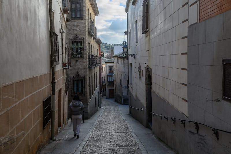 Narrow cobblestone street lined with historic buildings in Toledo old town Spain