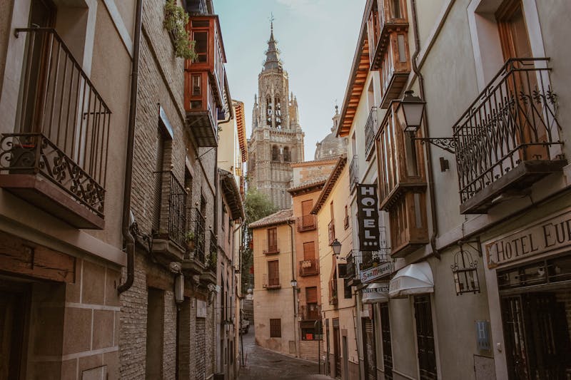 Charming street in Toledo with the cathedral tower visible in the background