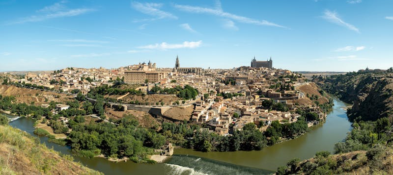 Stunning panoramic view of Toledo Spain with the Tagus River and historic architecture under clear blue sky